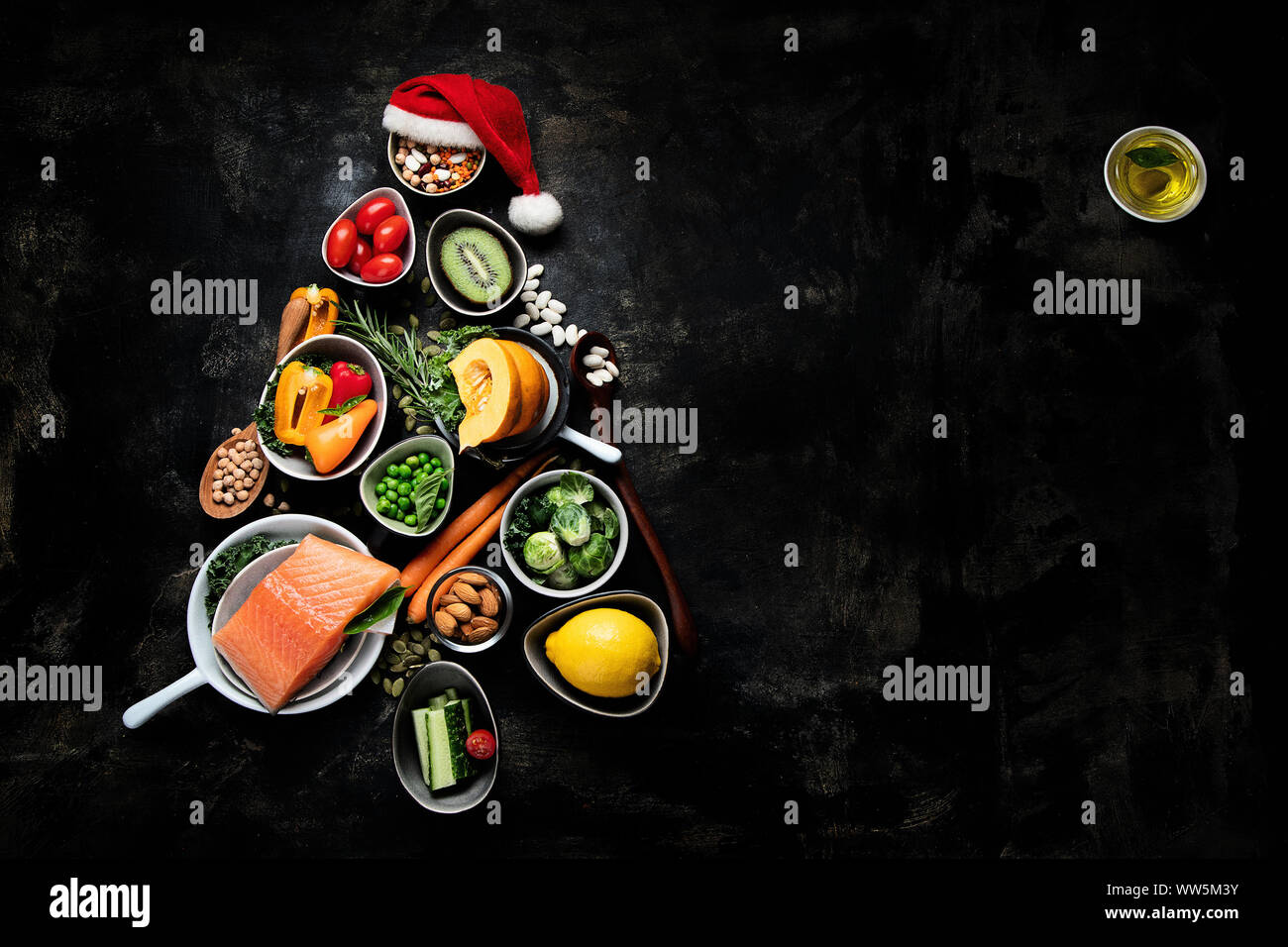 Christmas tree made of healthy food on black background. Top view with ...