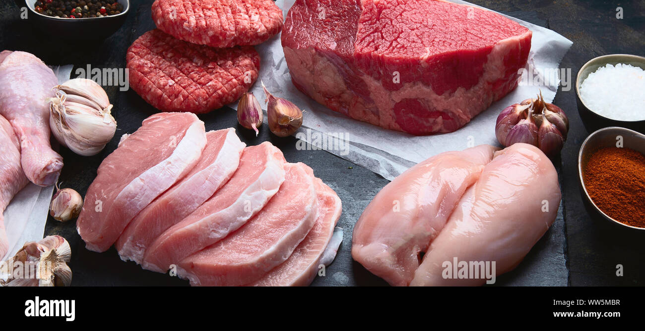 Raw meat assortment on black background, panorama, banner Stock Photo ...