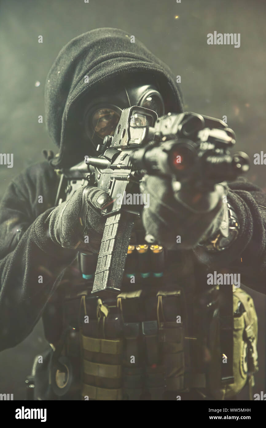 Elite special unit soldier is holding assault rifle and aiming at the ...