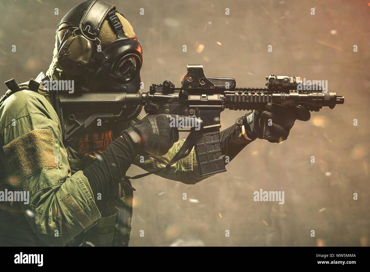 Elite special unit soldier with gasmask is holding assault rifle and ...
