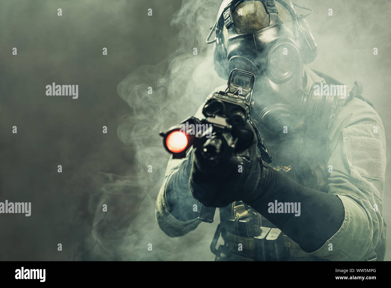 Special force soldier with gasmask between smoke at battlefield is ...