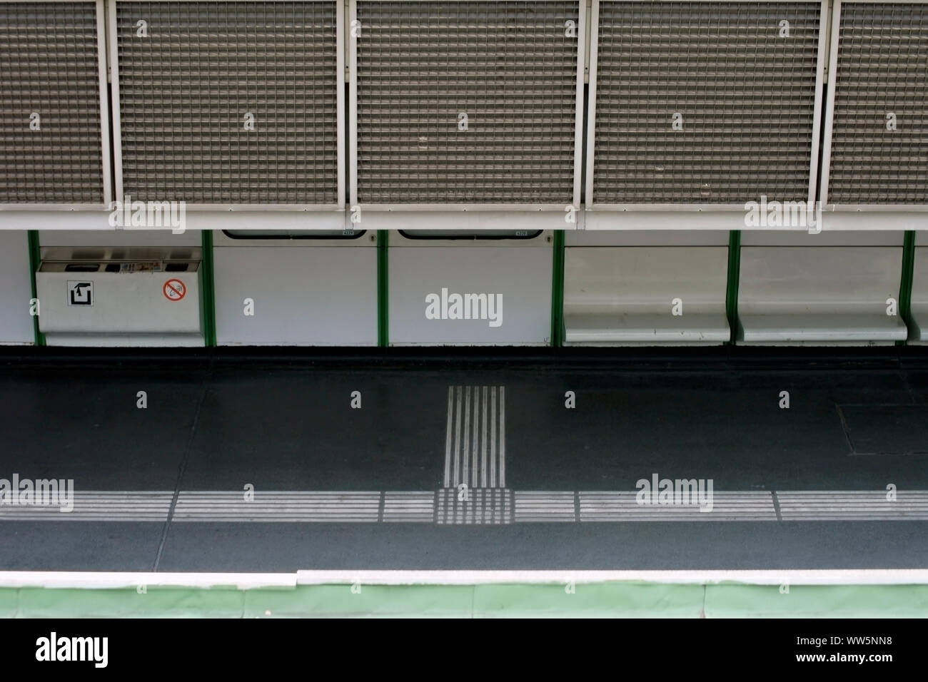 Photography of a roof overhang of a platform with seats and refuse bin ...
