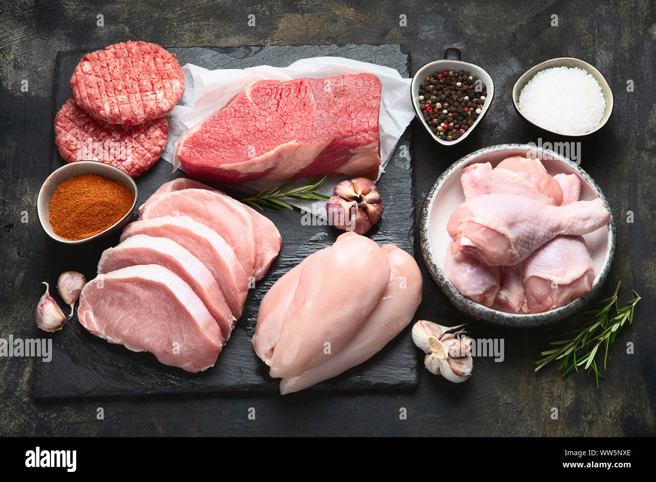 Different types of raw meat on black background. Top view Stock Photo ...