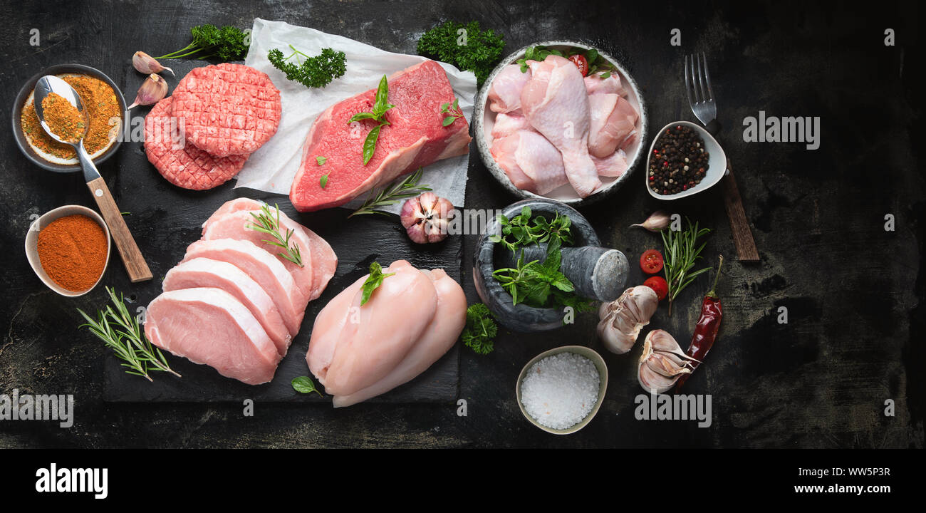 Different types of raw meat on black background. Top view with copy ...