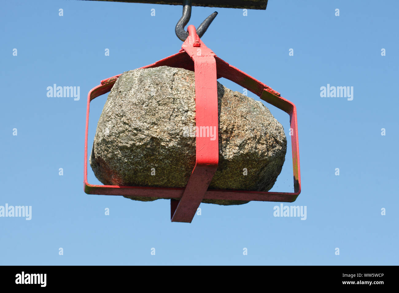 Stone hanging on a crane hook, old wood hoisting crane at Varel harbour ...