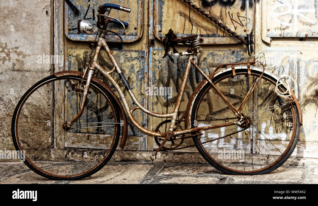 Old rusty bike at the door covered with graffiti Stock Photo - Alamy