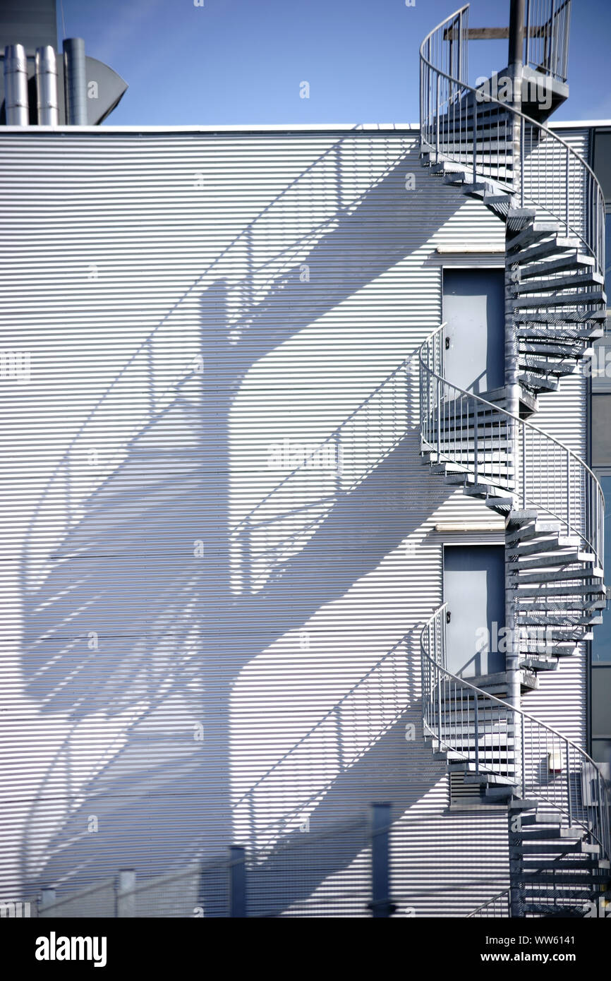 A spiral staircase, fire escape, side view facade of an industrial ...