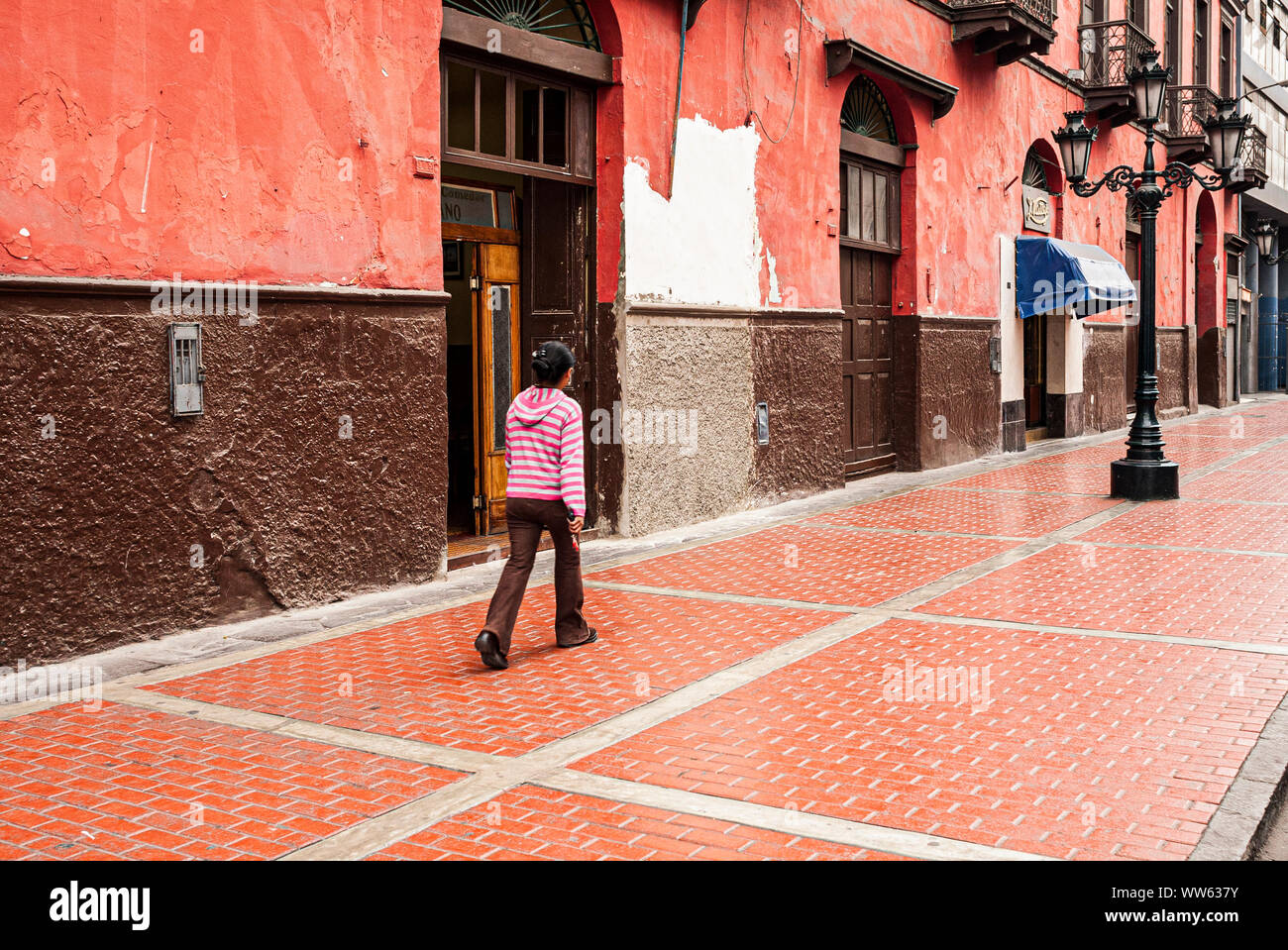 Person walking on the sidewalk of a street in historic center of Lima ...