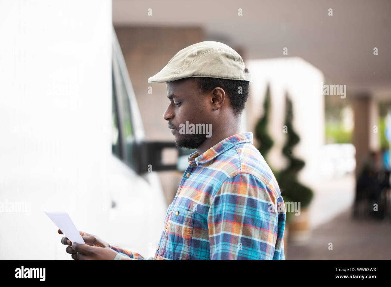 Portrait of a man standing by a truck looking at paperwork Stock Photo ...