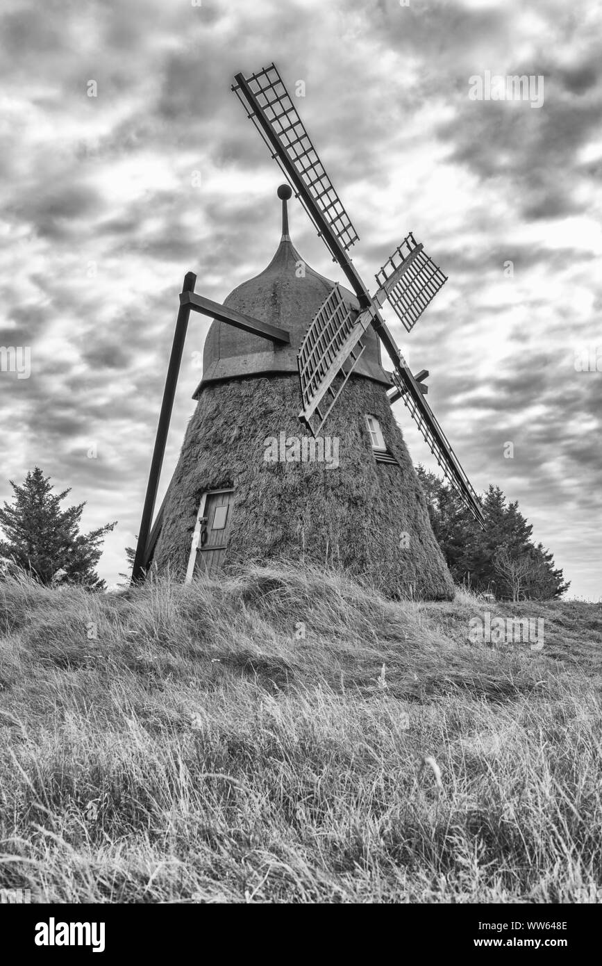 cloud-covered sky with a small old thatched windmill, b/w Stock Photo ...