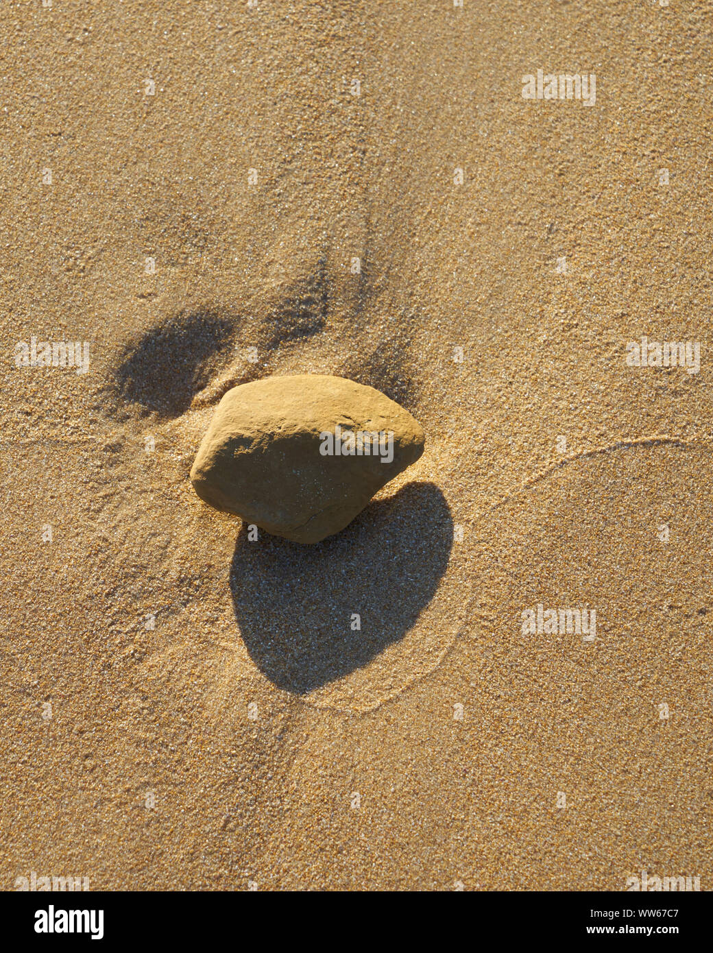 Stone with connection as a line in sand Stock Photo - Alamy