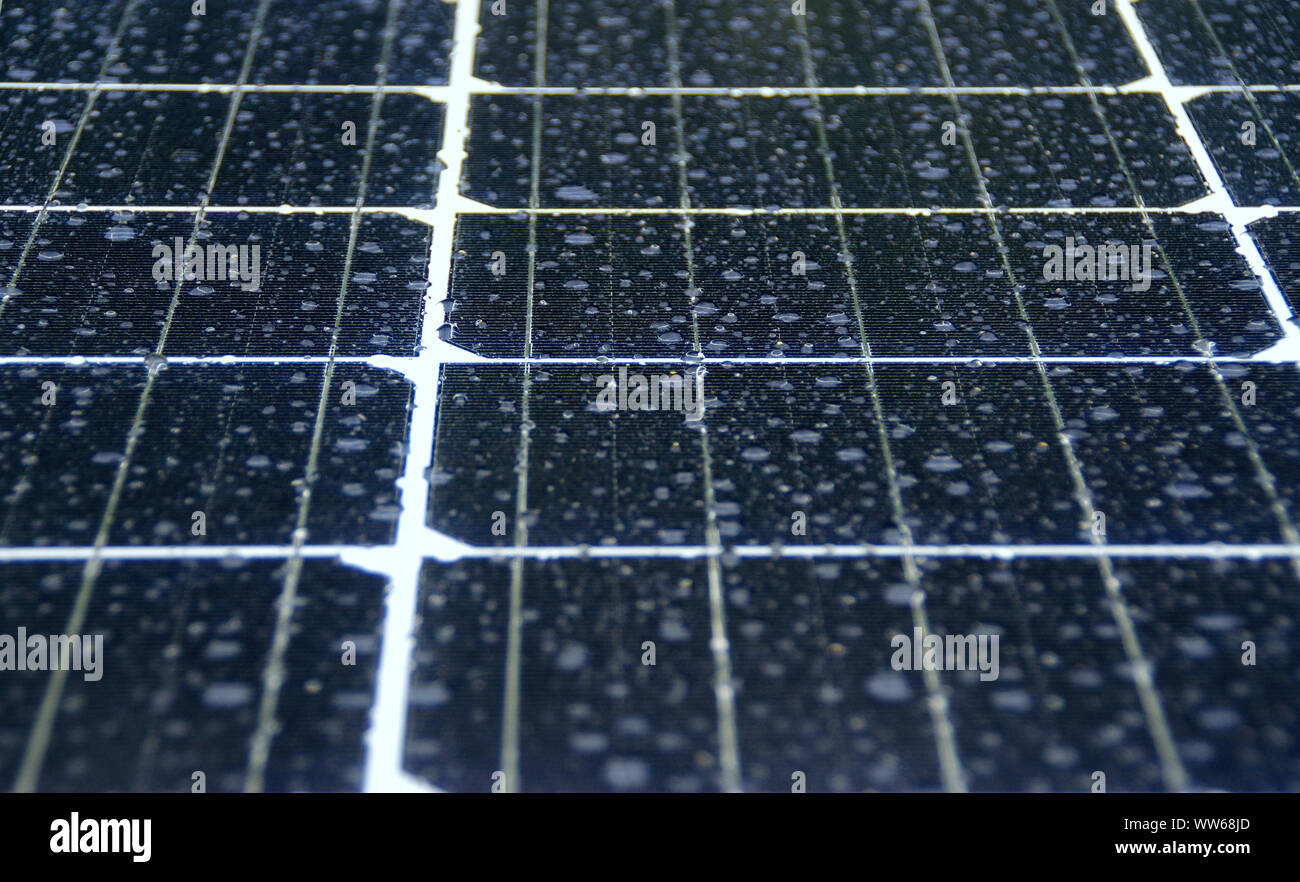 Photovoltaic solar energy panels in the rain. Water raindrops on cell ...