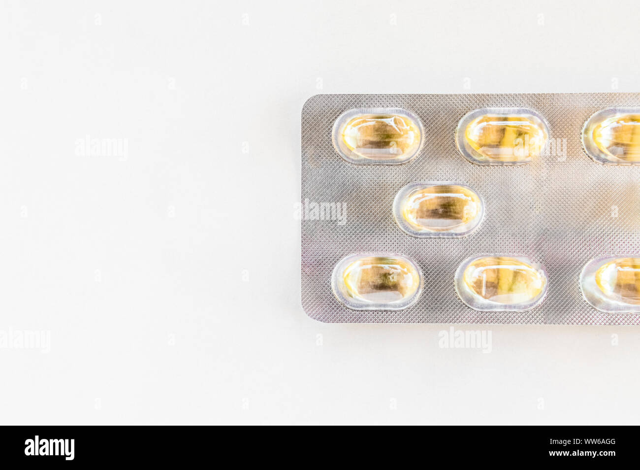 Top view of yellow capsules on white background. Medication concept ...