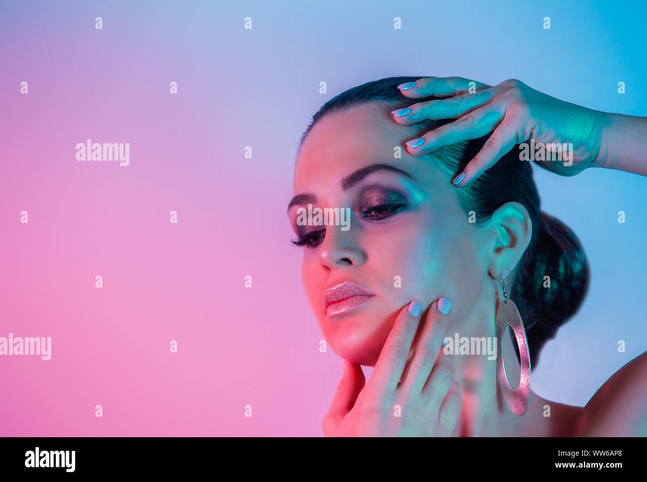 Make up and Beauty Woman with pink and blue neon light on her face with ...