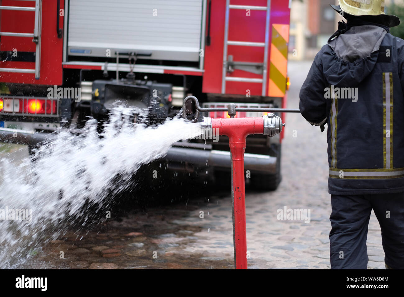 The fireman opens a fire hydrant to extinguish a fire Stock Photo - Alamy