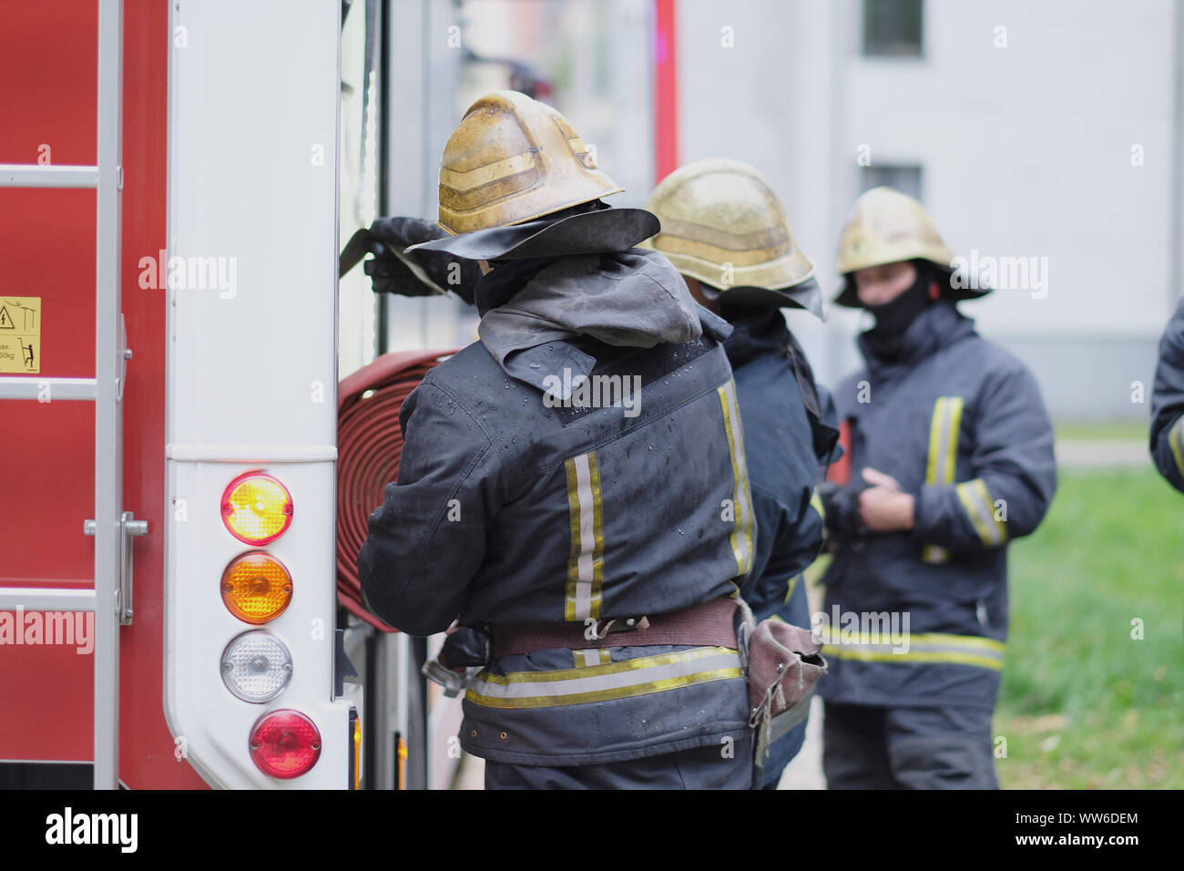 Members of the fire brigade store the equipment after the work done in ...