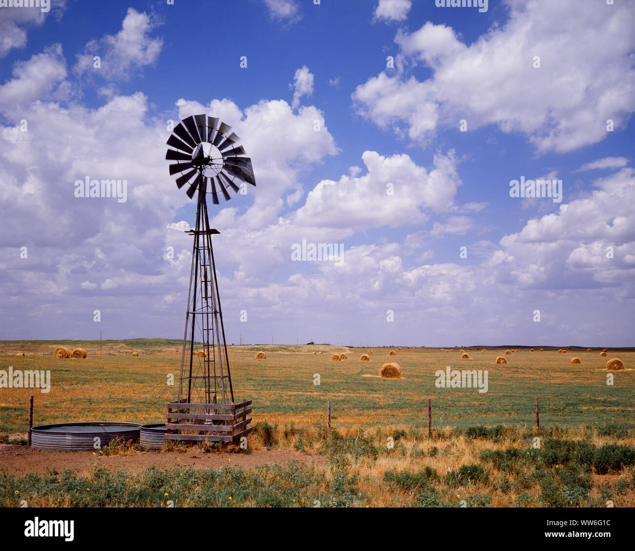1980s WINDMILL PUMP FULL WATERING TROUGH AND FIELD OF BALED HAY BLUE ...