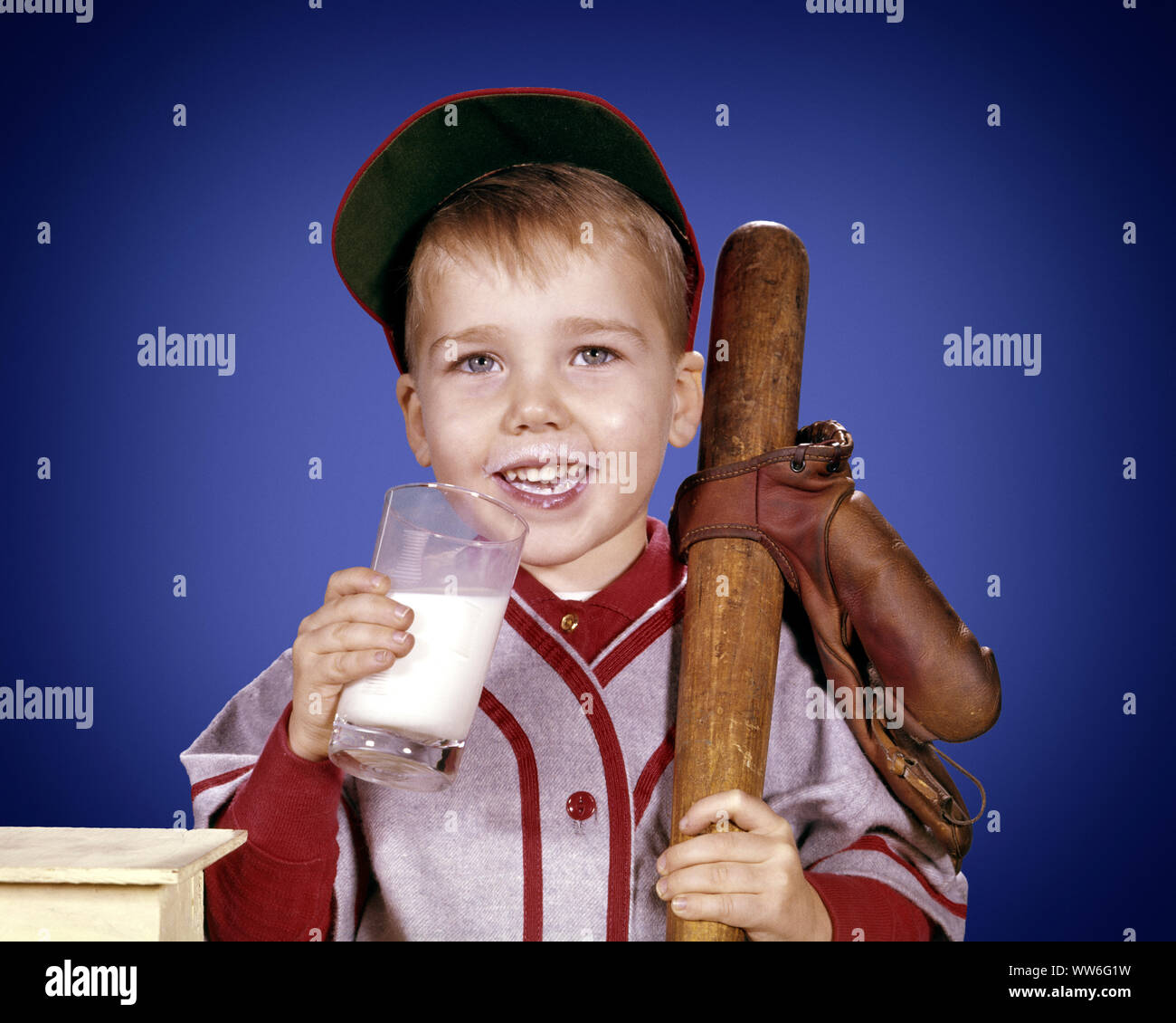 1960s SMILING BOY LOOKING AT CAMERA WEARING BASEBALL UNIFORM DRINKING ...