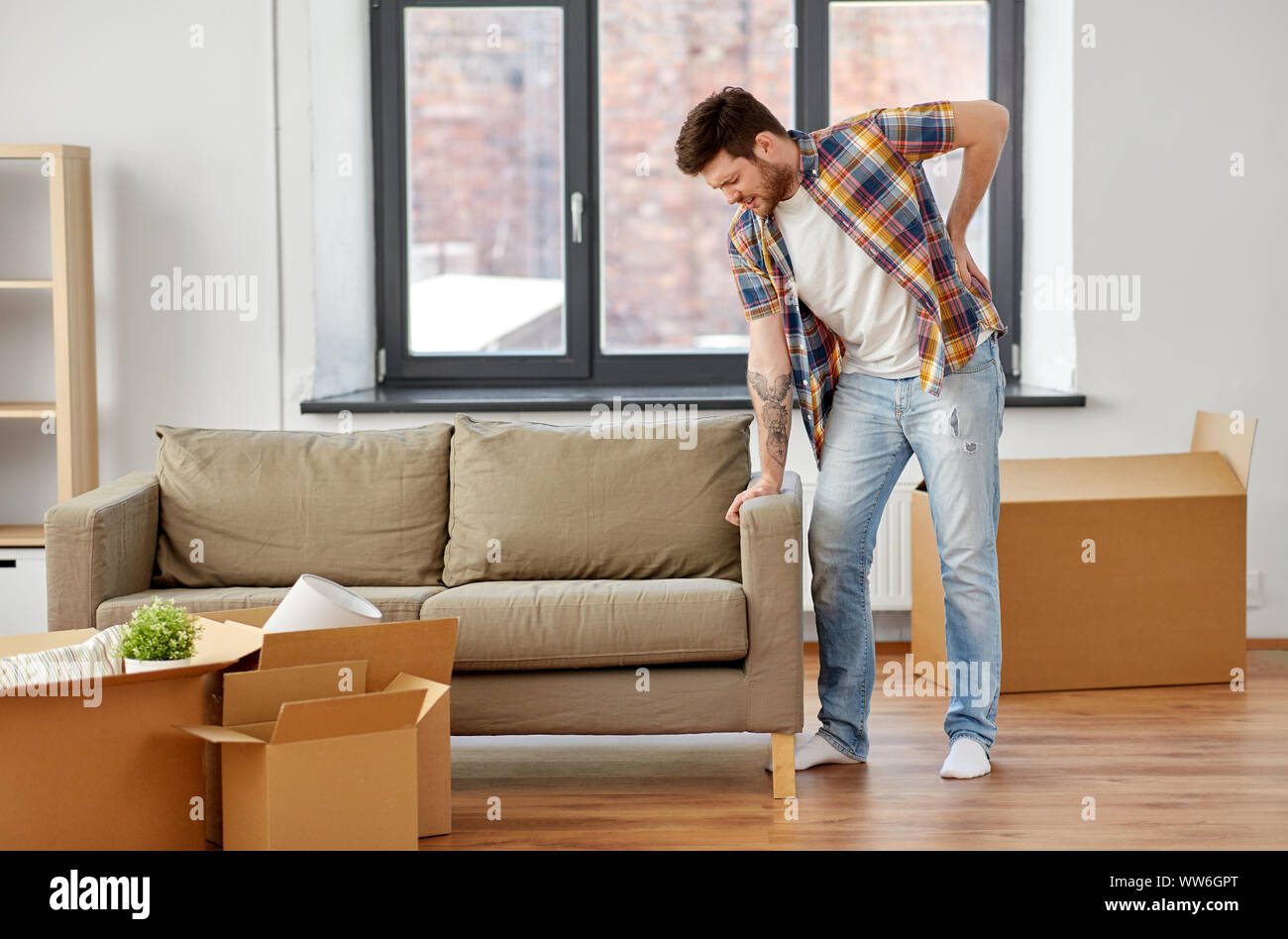 man having back ache moving to new home Stock Photo - Alamy