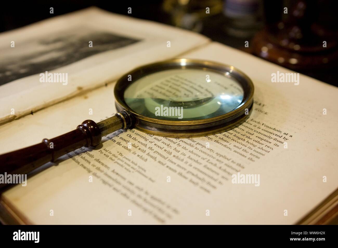 Magnifying glass on book Stock Photo - Alamy