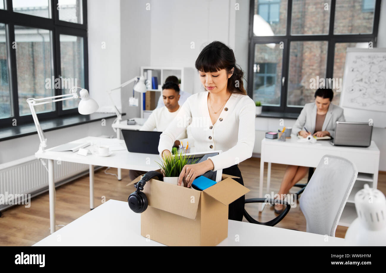 sad female office worker packing personal stuff Stock Photo - Alamy