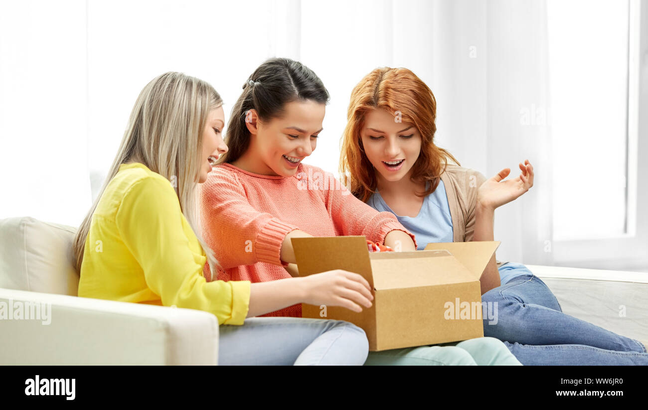 teenage girls or friends opening parcel box Stock Photo - Alamy