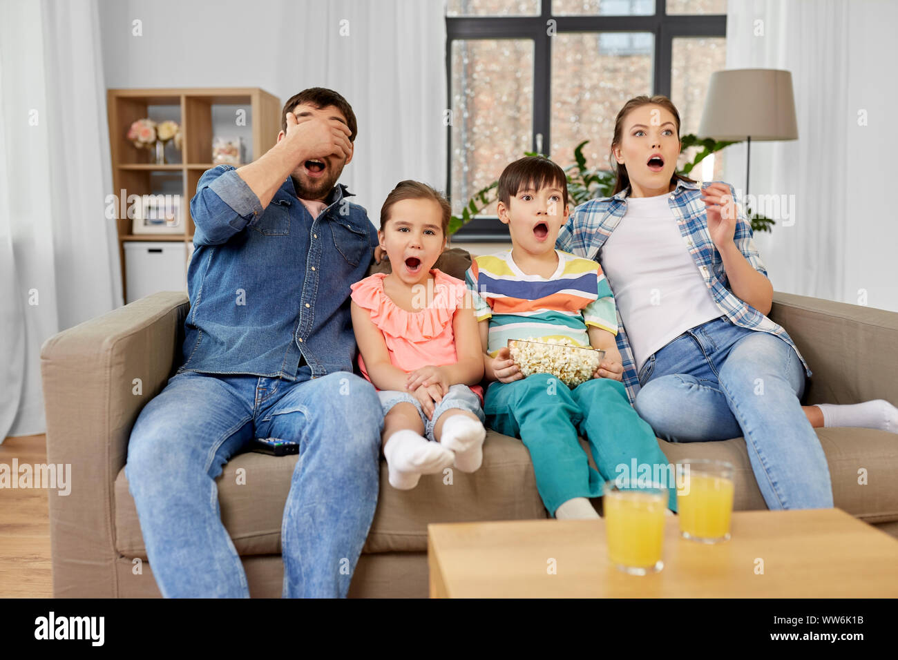 scared family with popcorn watching horror on tv Stock Photo - Alamy