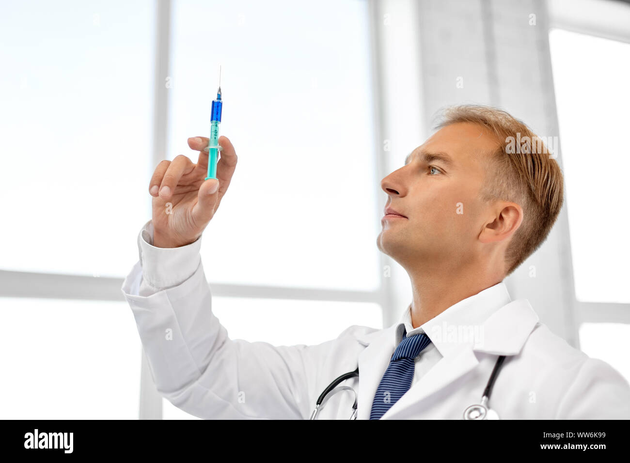 smiling doctor with syringe at hospital Stock Photo - Alamy