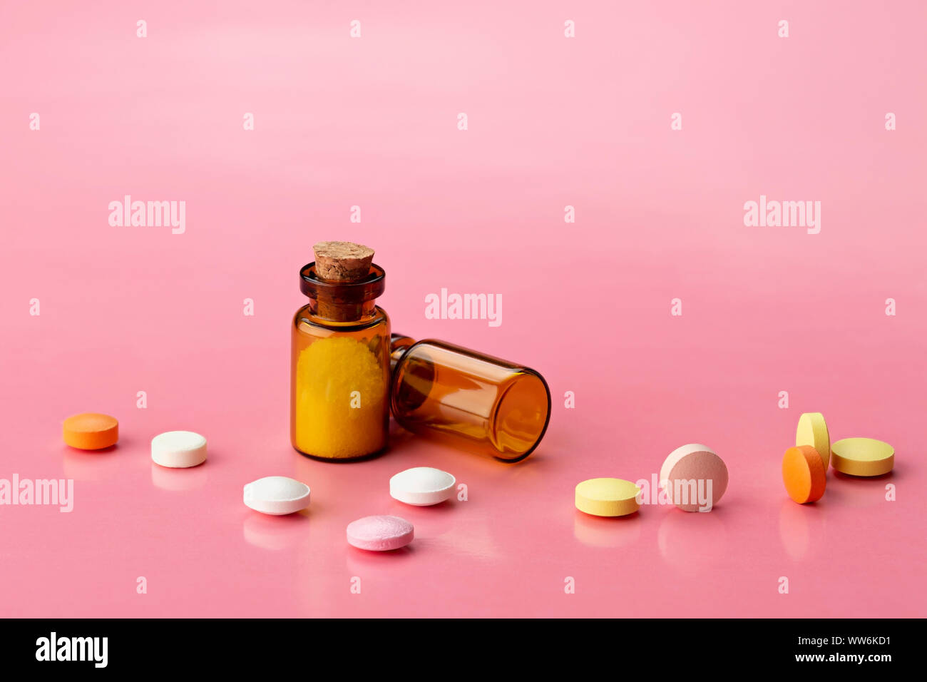 two brown glass bottles and different round coloured tablets Stock ...