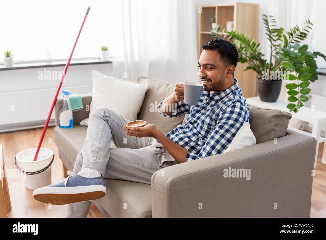 man drinking coffee, resting after home cleaning Stock Photo - Alamy