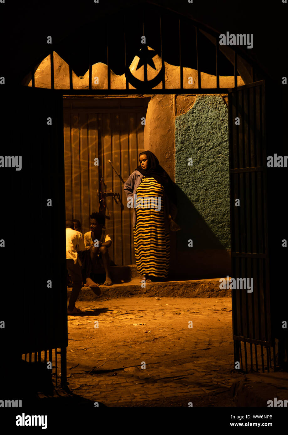 Harari woman at the entrance of a holy shrine at night, Harari region ...