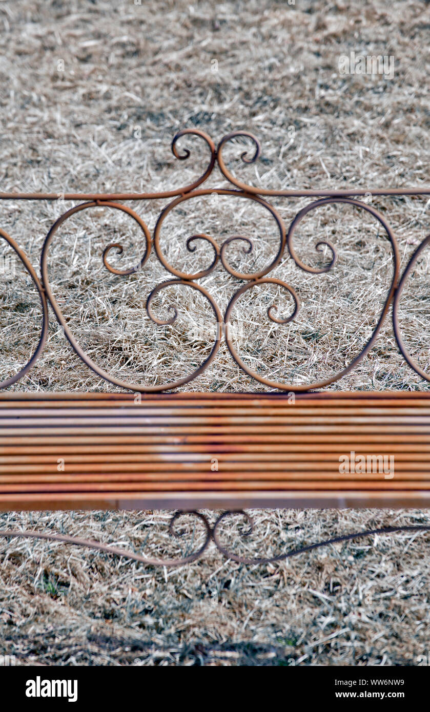 filigree rusty park bench in front of meadow area Stock Photo - Alamy
