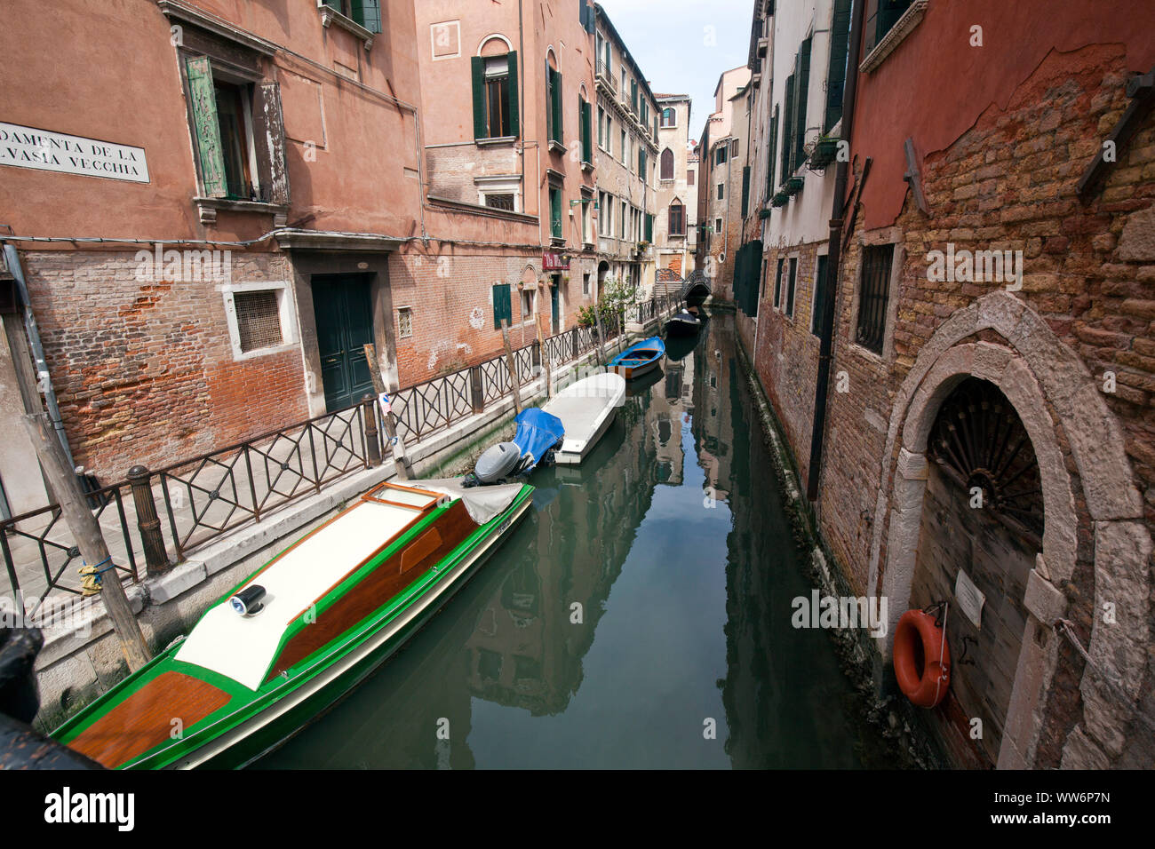 Narrow canal with boats between houses in venice hi-res stock ...