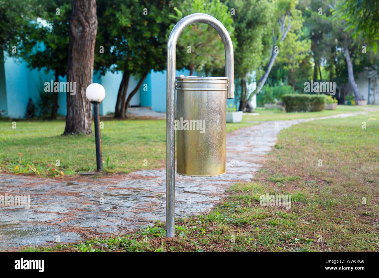 Metal trash can on the sidewalk Stock Photo - Alamy