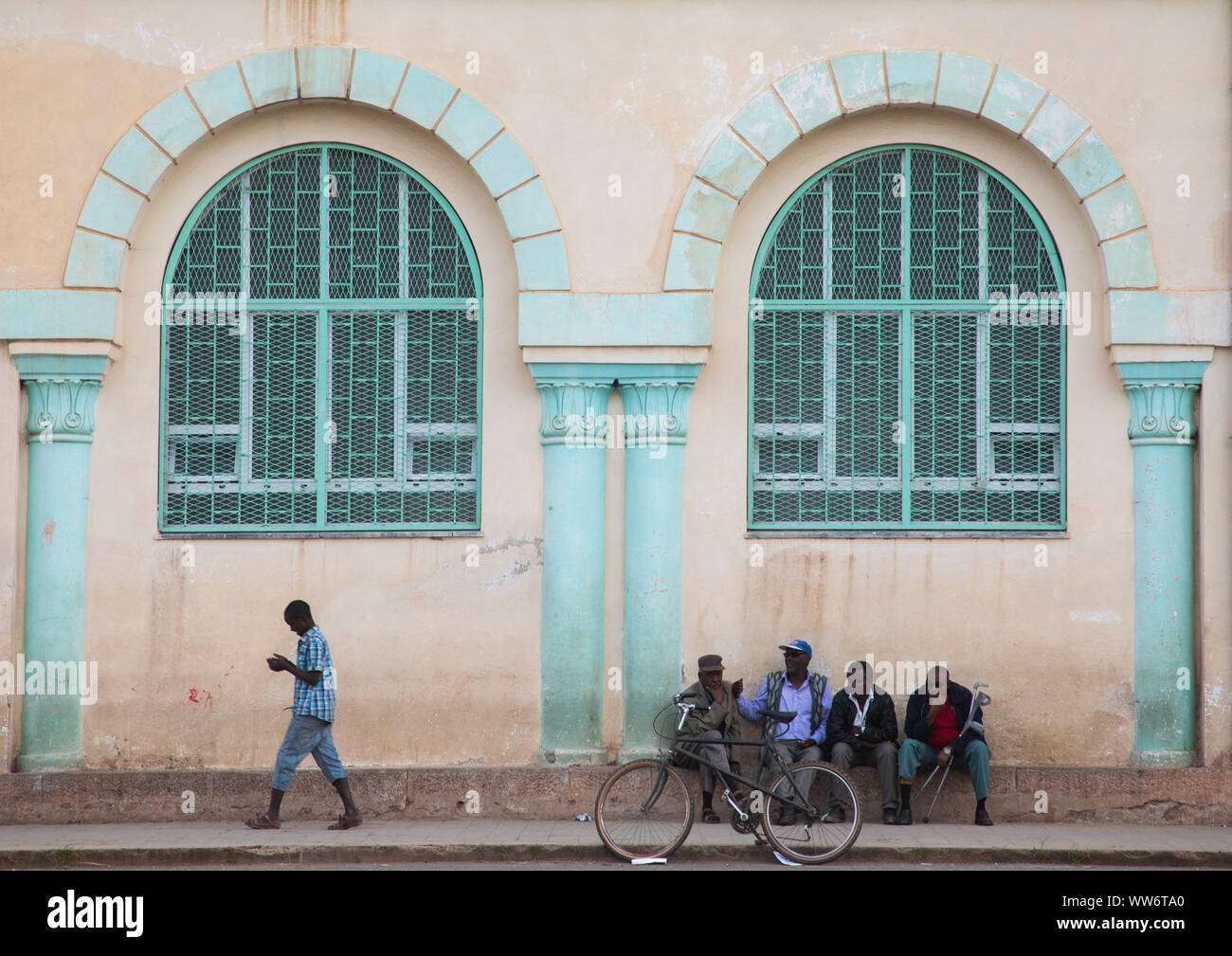 Eritrean people in front of a building from the italian colonial times ...