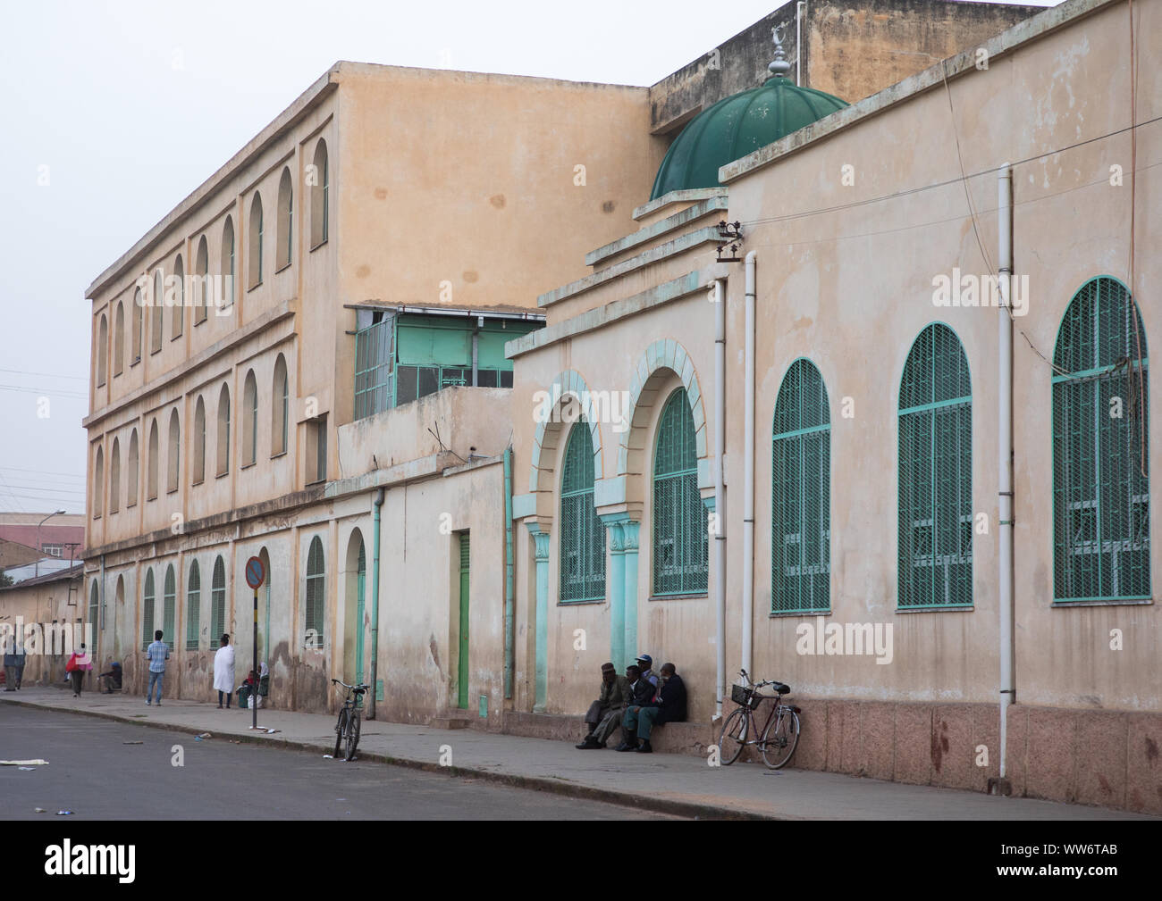 Eritrean people in front of a building from the italian colonial times ...