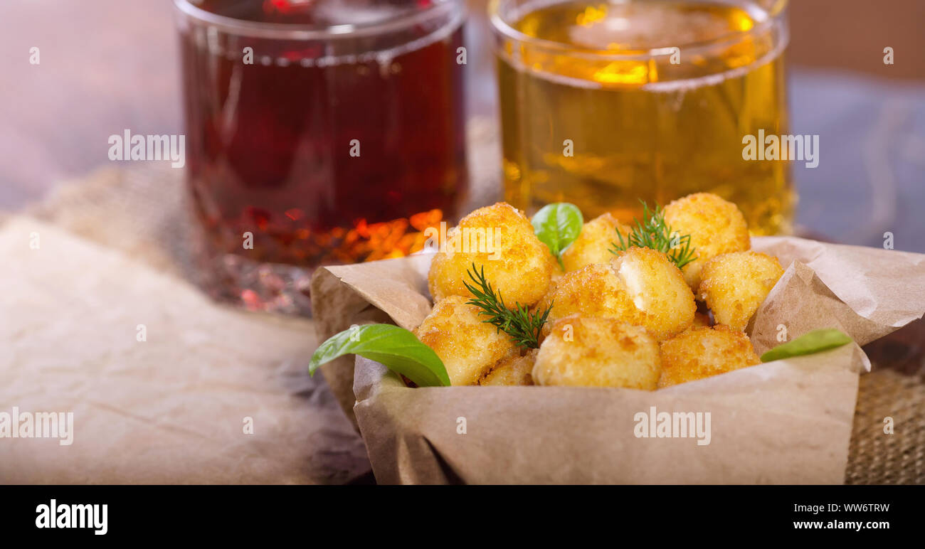 Beer snacks. Fried fried fish and cheese balls with lemon and greens ...
