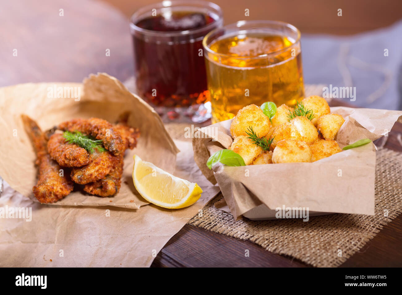 Beer snacks. Fried fried fish and cheese balls with lemon and greens ...
