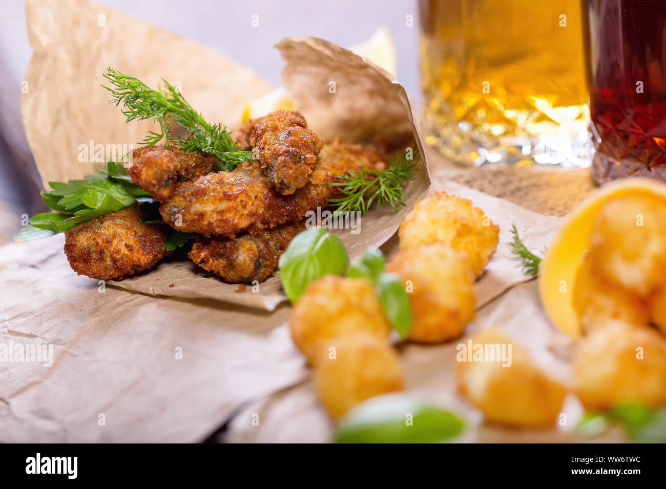 Beer snacks. Fried fried fish and cheese balls with lemon and greens ...