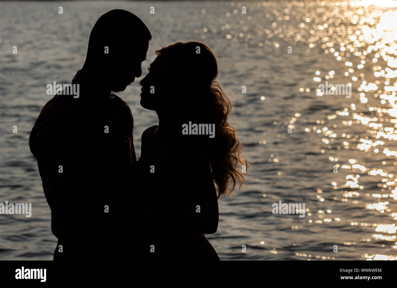Shadow of the couple on the water at sunset time Stock Photo - Alamy