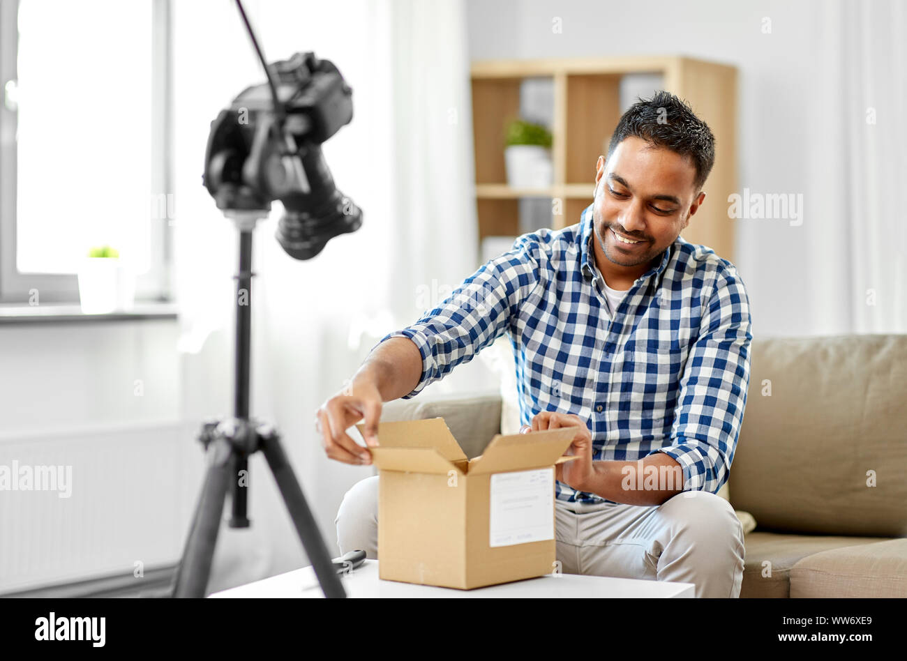 male video blogger opening parcel box at home Stock Photo - Alamy