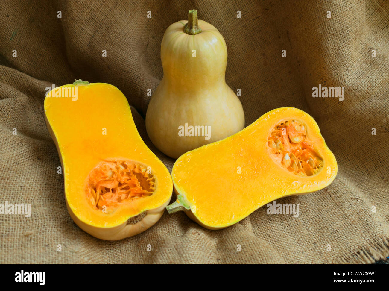 Whole and cut in half pumpkins on a brown background. Close-up. Autumn ...