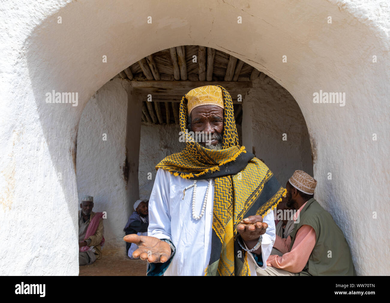 Oromo pilgrim man with his shoes in the hands in Sheikh Hussein shrine ...