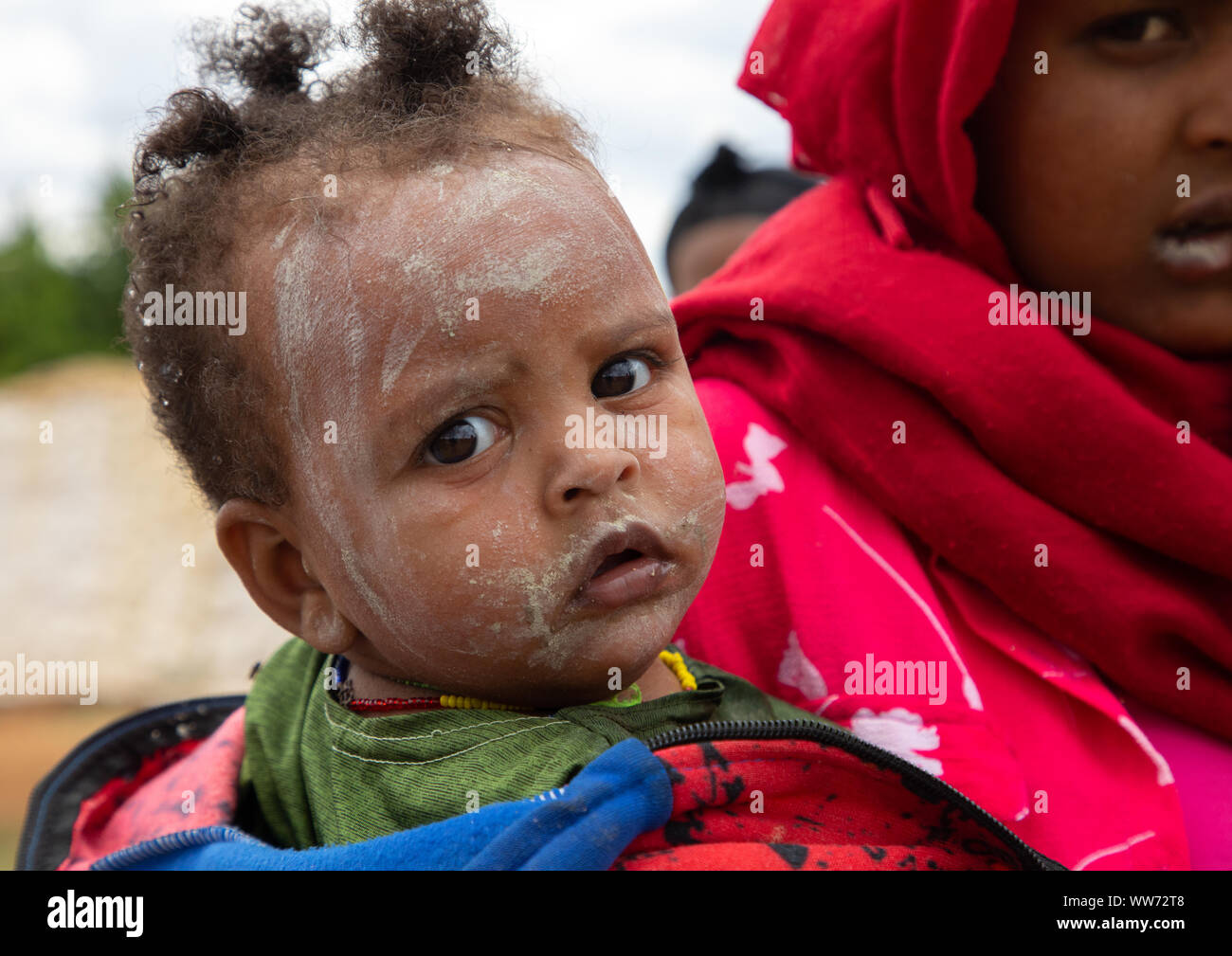 Oromo toddler with her mother in Sheikh Hussein shrine with jarawa ...