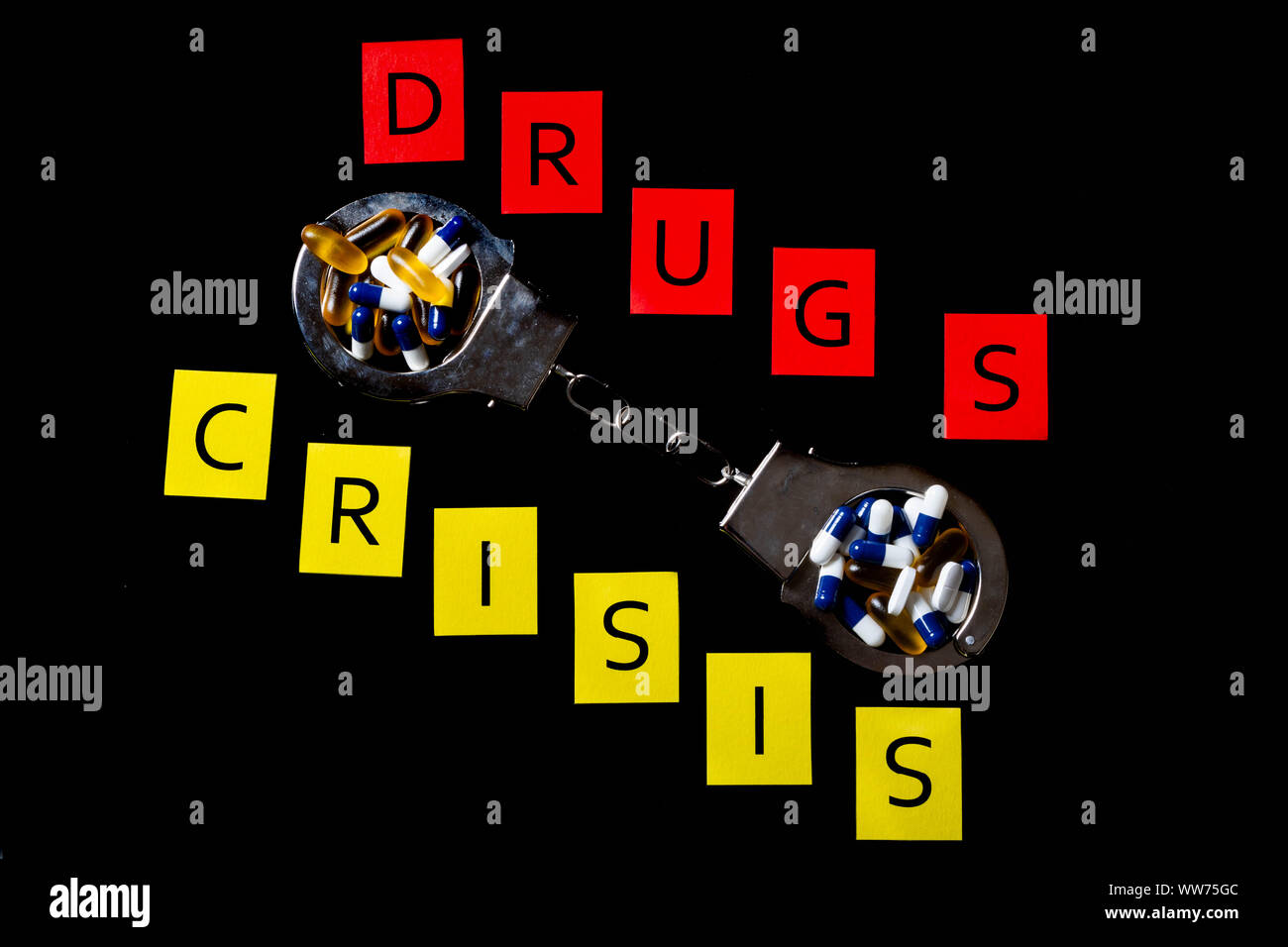 Illegal drug crisis concept showing tablets, handcuffs and the message ...