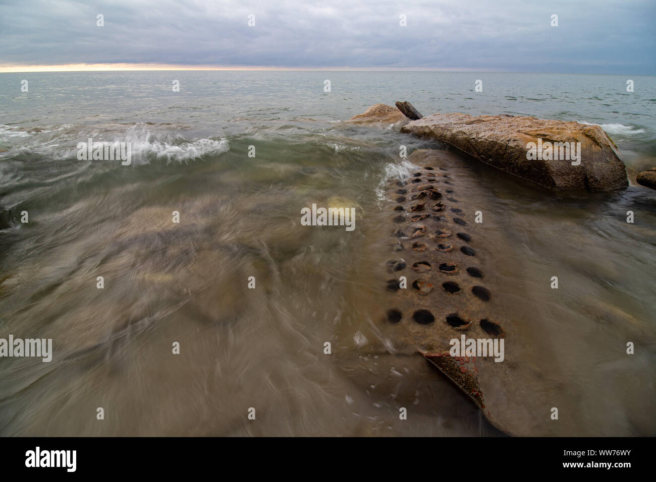Stone block and strange rusty structure with holes in it Stock Photo ...