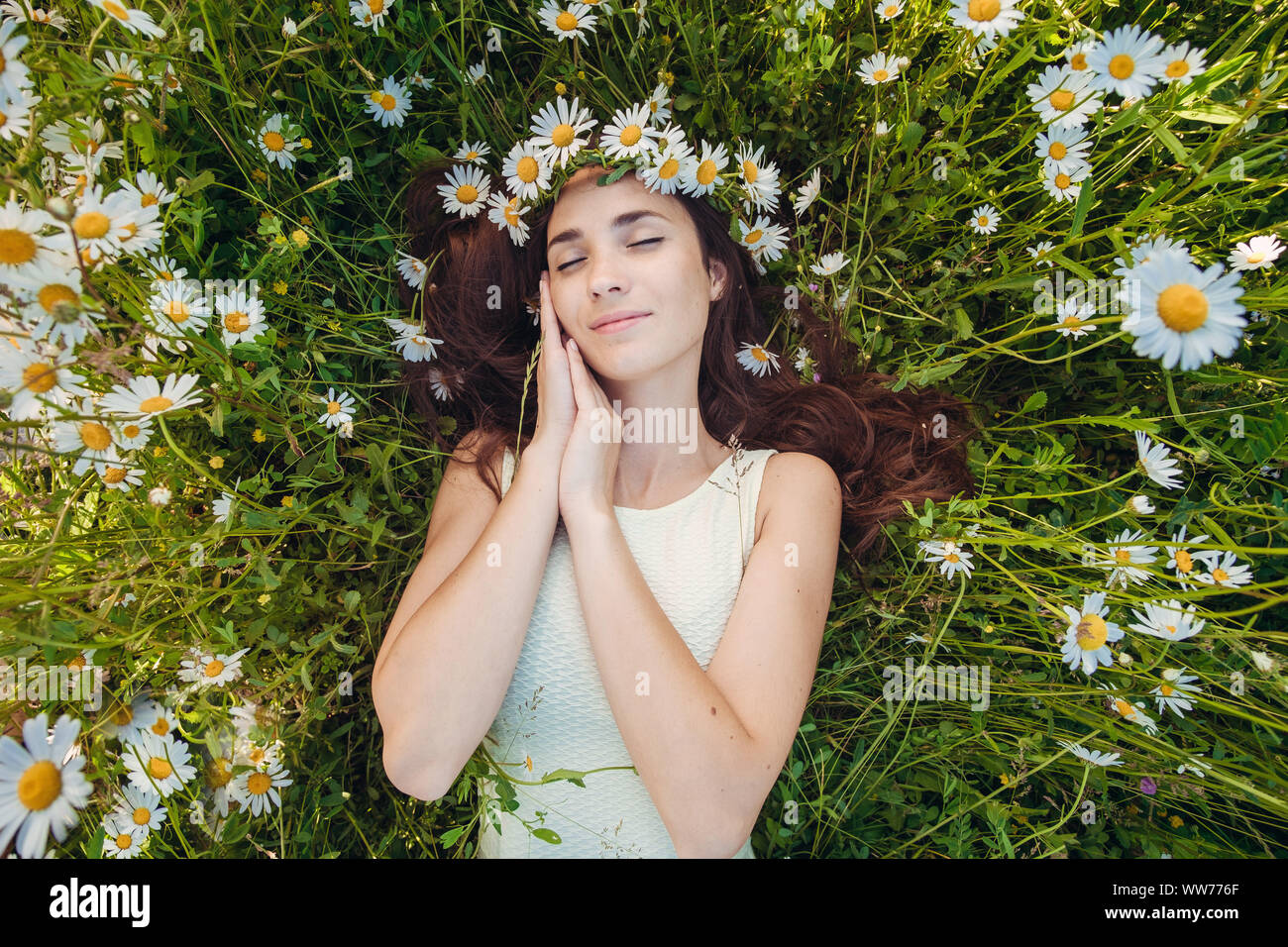 The beautiful woman lies in the field of chamomiles. . Carefree happy ...