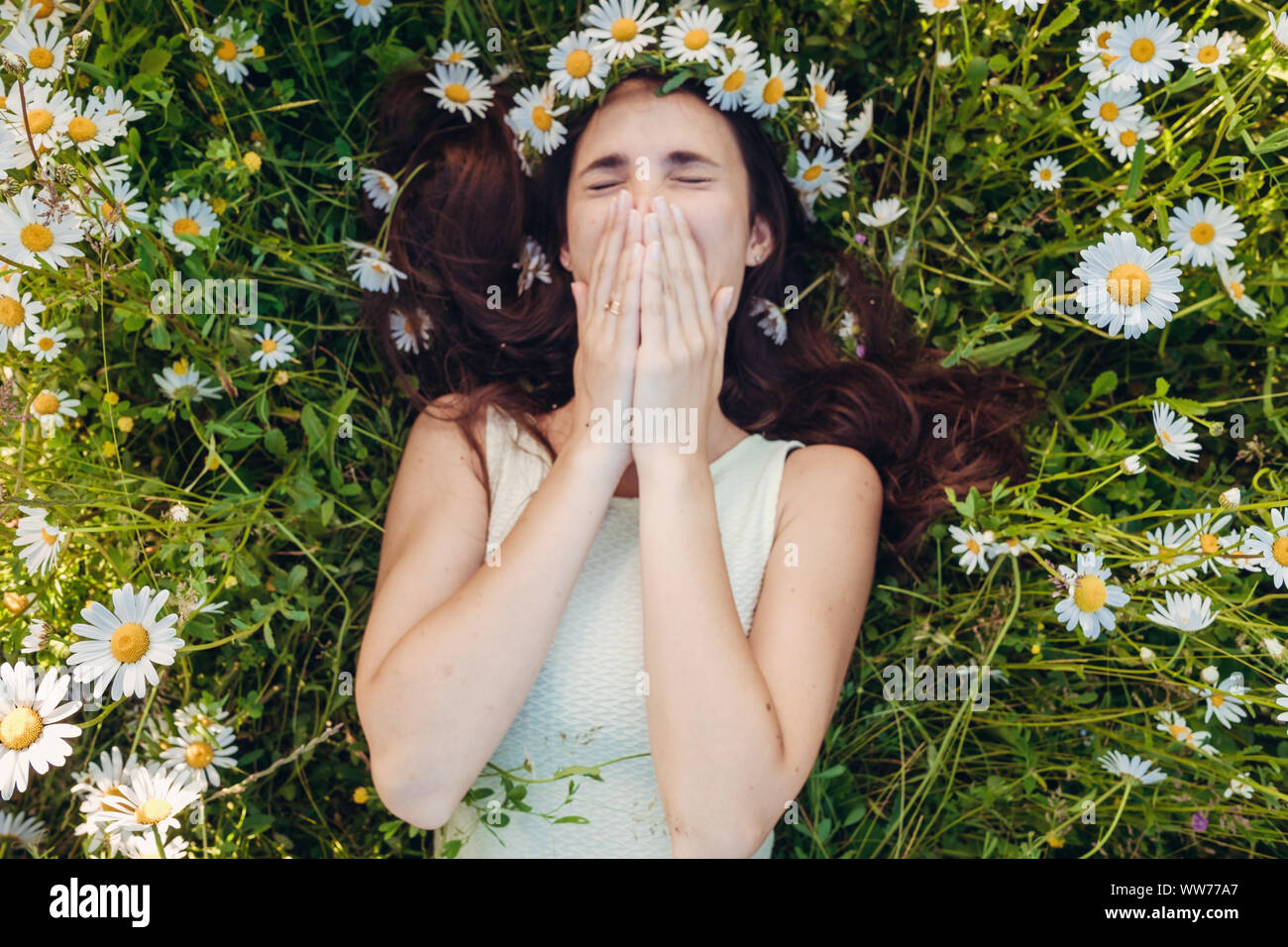 The beautiful woman lies in the field of chamomiles. . Carefree happy ...