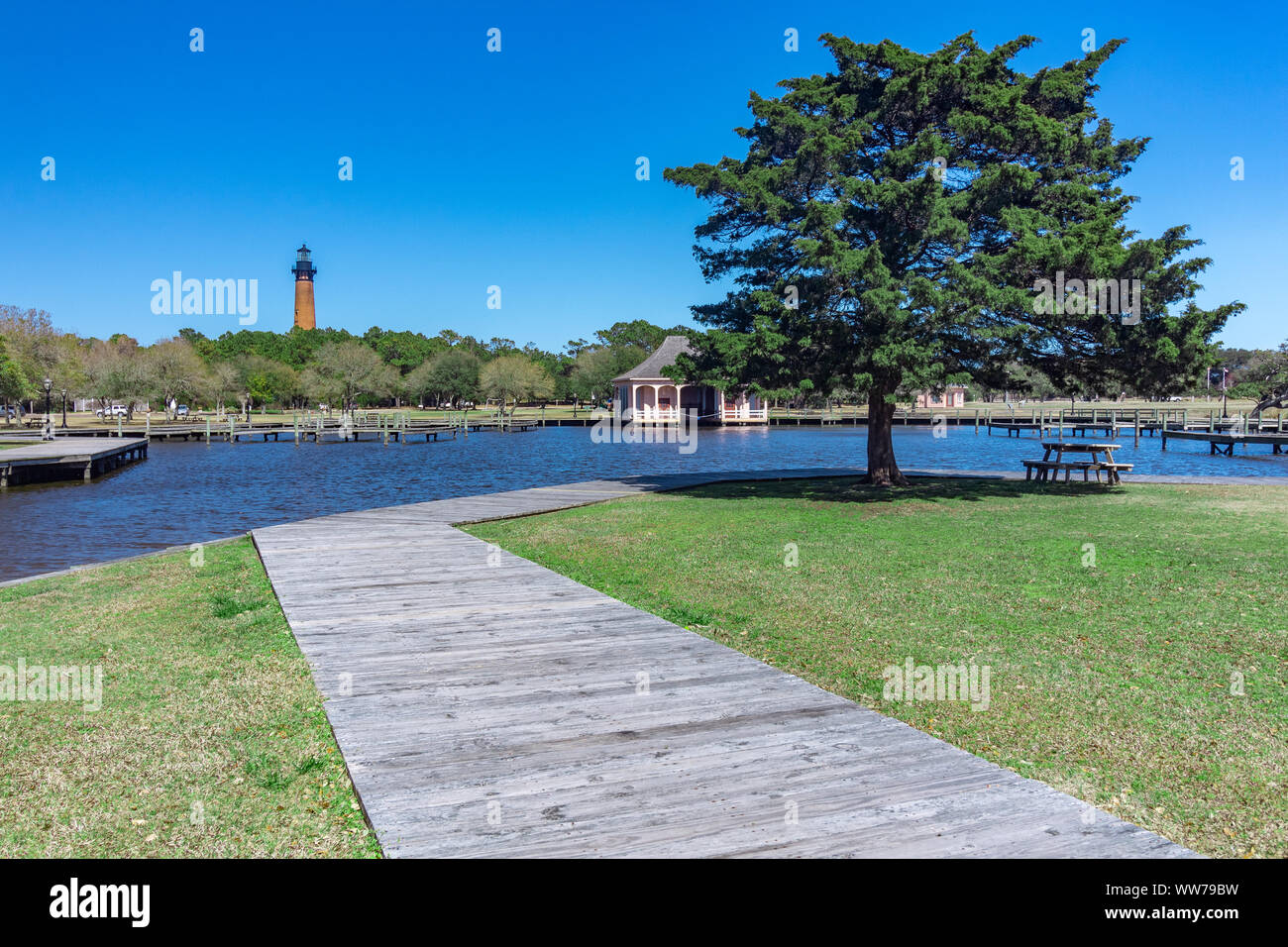 Boardwalk and boat dock with lighthouse in the background Stock Photo ...