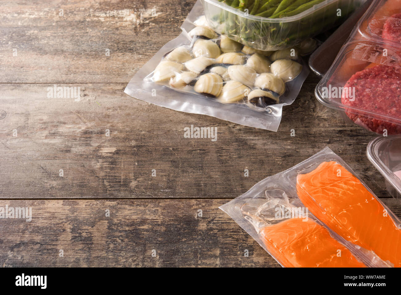 different types of packaged food. Beef,vegetables and seafood on wooden ...